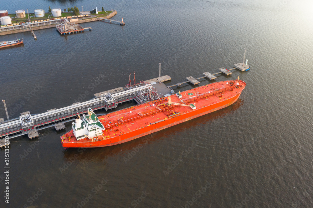 Oil tanker in industrial port at unloading of bulk contents, aerial ...