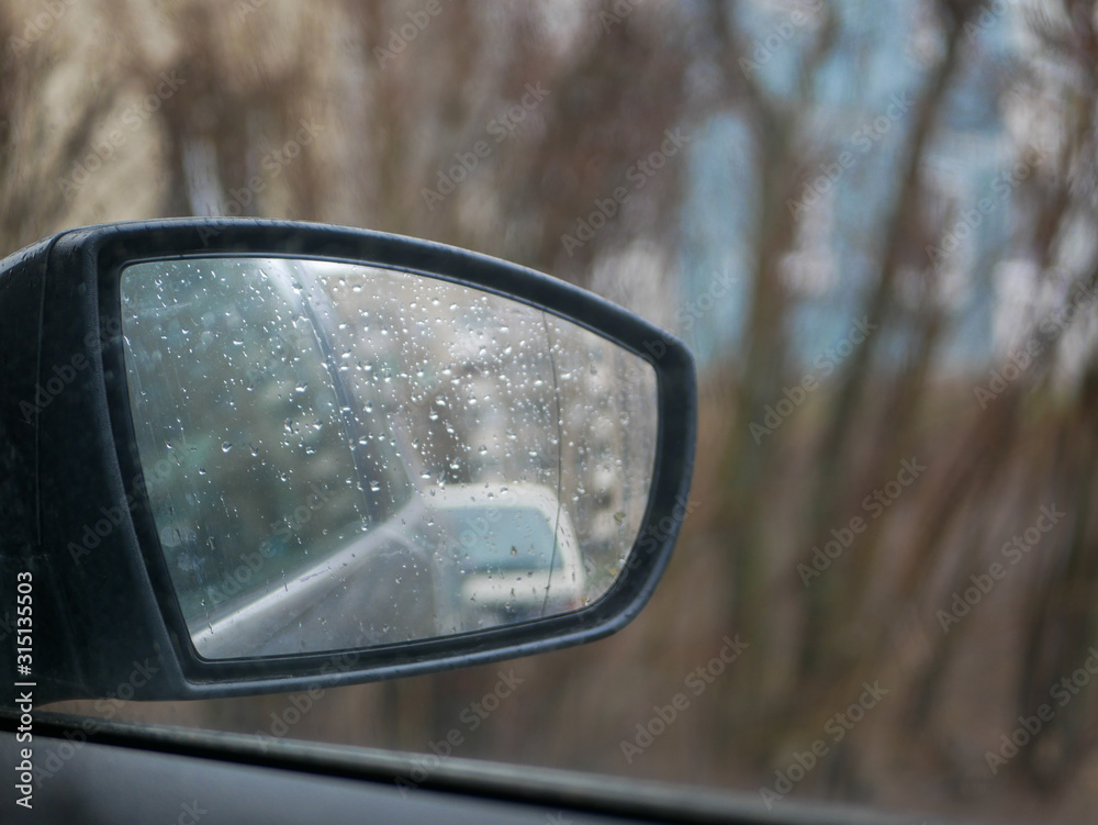 Rain behind the glass of a car. Rain droplets flow down the car glass ...