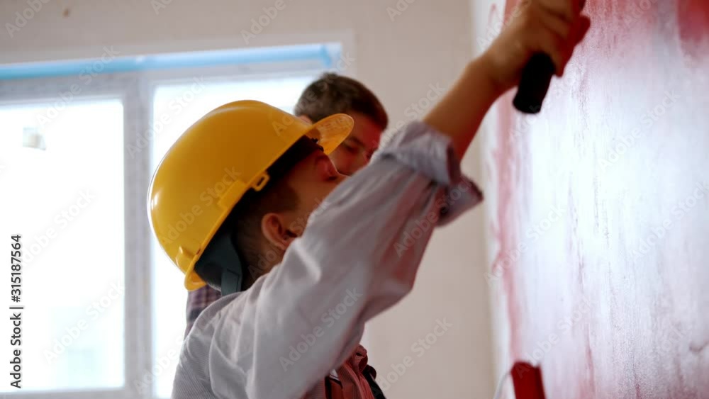 Family repair the apartment - little boy and his father painting wall ...