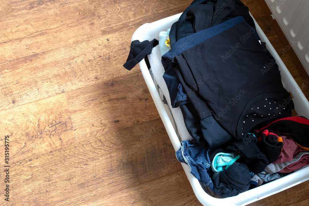 clothes in a full laundry basket on a laminaat floor, top view Stock ...