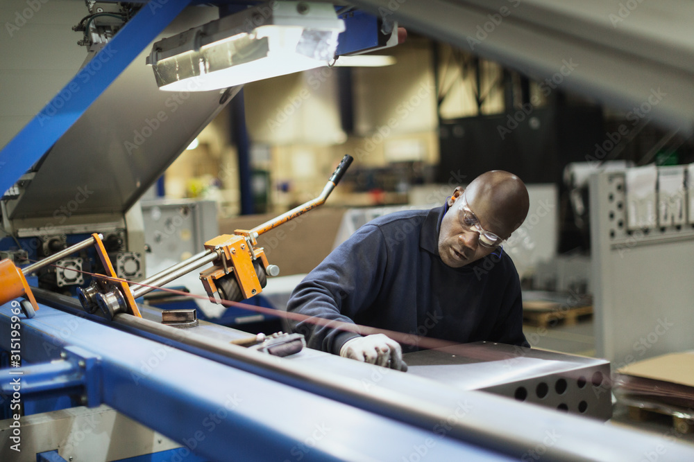 Worker operating machinery in steel factory Stock Photo | Adobe Stock
