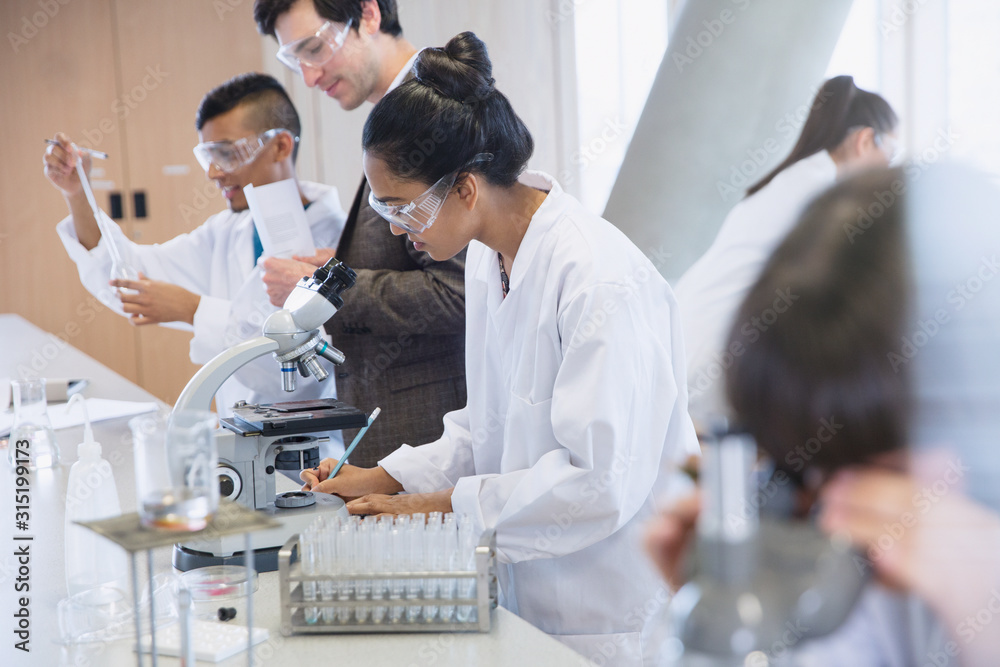 Female college students conducting scientific experiment in science ...