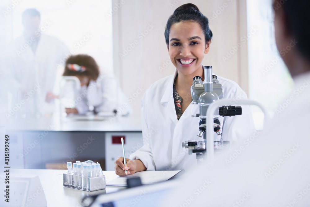 Smiling female college student conducting scientific experiment in ...