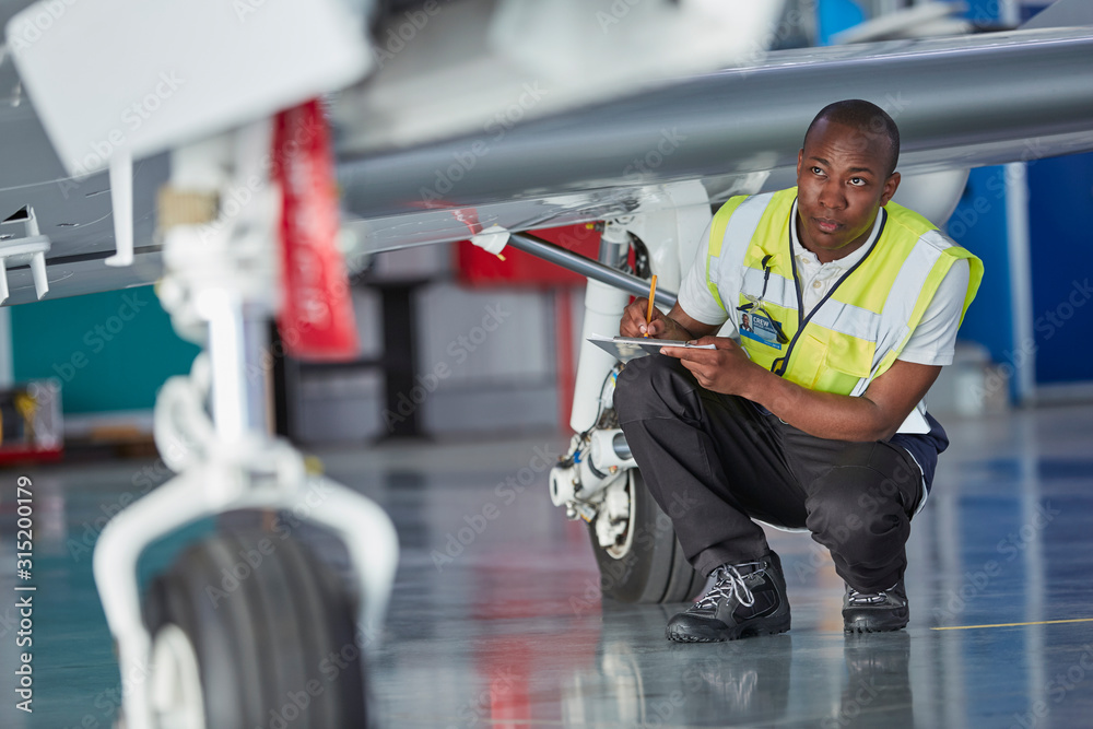 Ground crew worker with clipboard checking airplane Stock Photo | Adobe ...