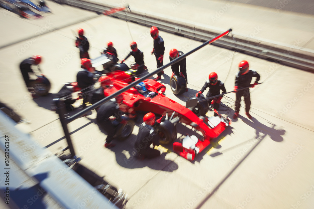 Pit crew replacing tires on formula one race car in pit lane Stock ...