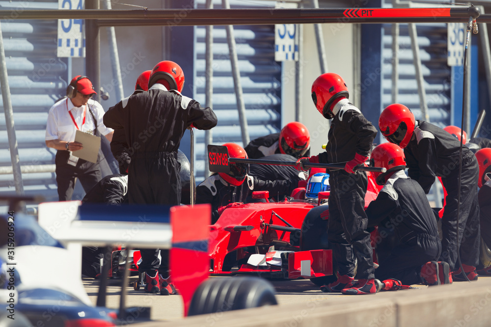 Pit crew replacing tires on formula one race car in pit lane Stock ...