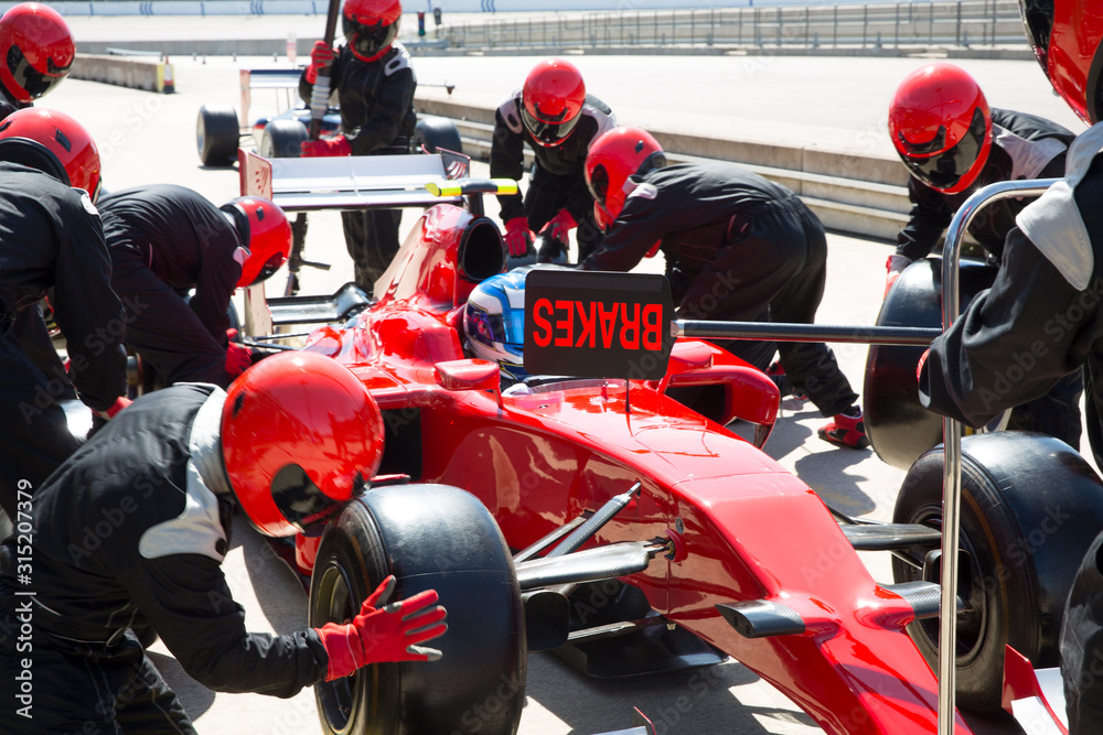 Pit crew replacing tires on formula one race car in pit lane Stock ...