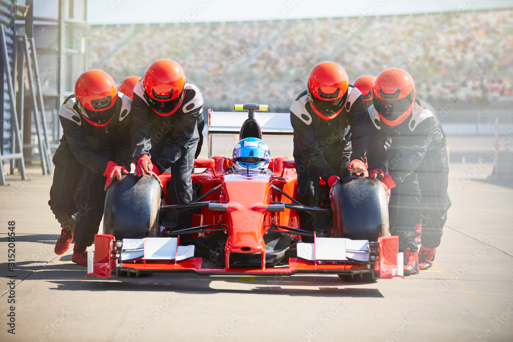 Pit crew pushing formula one race car out of pit lane Stock Photo ...