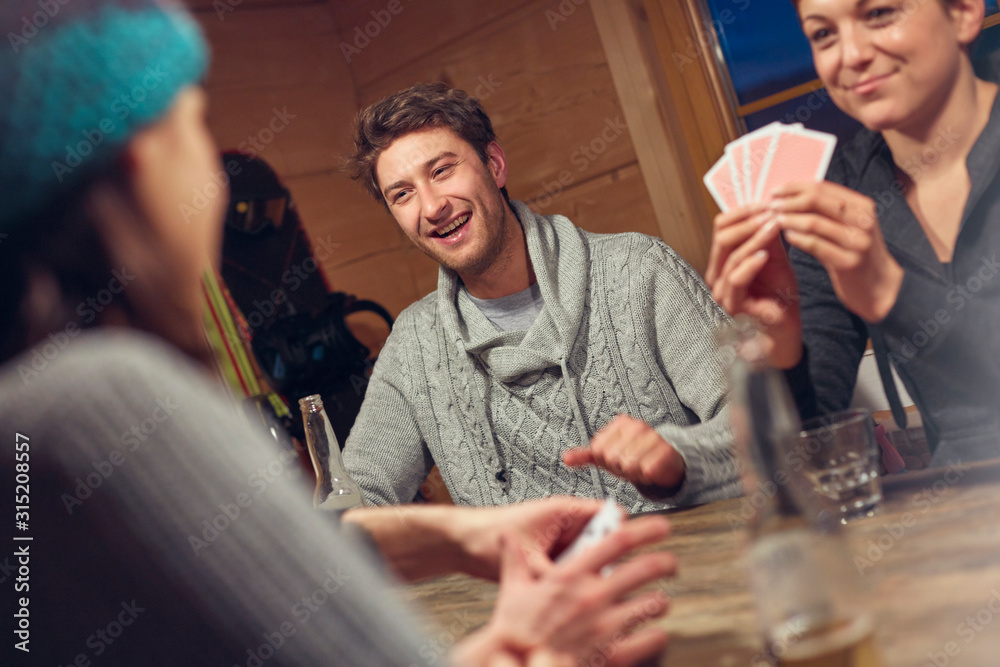 Friends playing cards at table in cabin Stock Photo | Adobe Stock