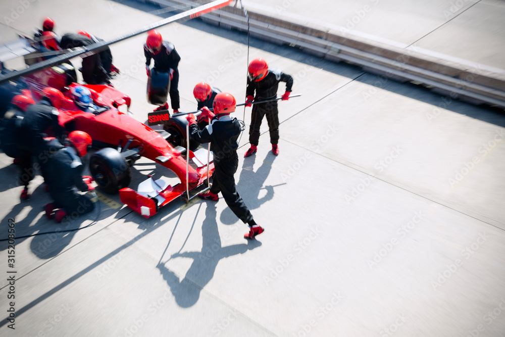 Pit crew replacing tires on formula one race car in pit lane Stock ...