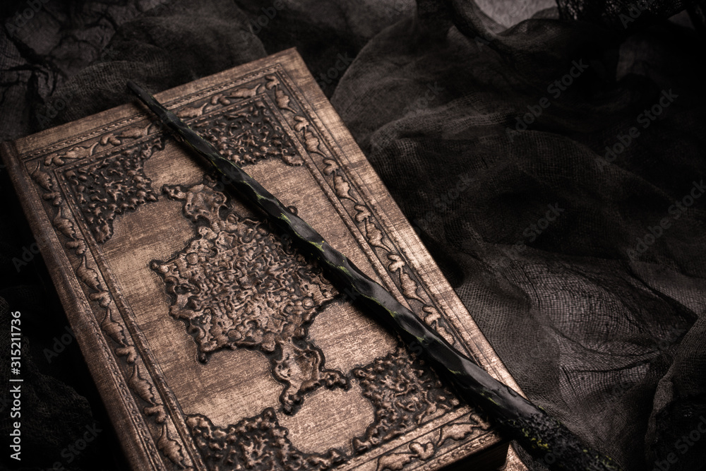Old book with spells and magic wand on gray background with witch rag ...