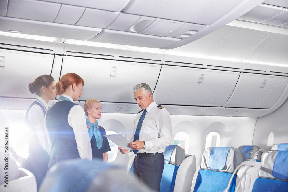 Pilot and flight attendants talking, preparing on airplane Stock Photo ...