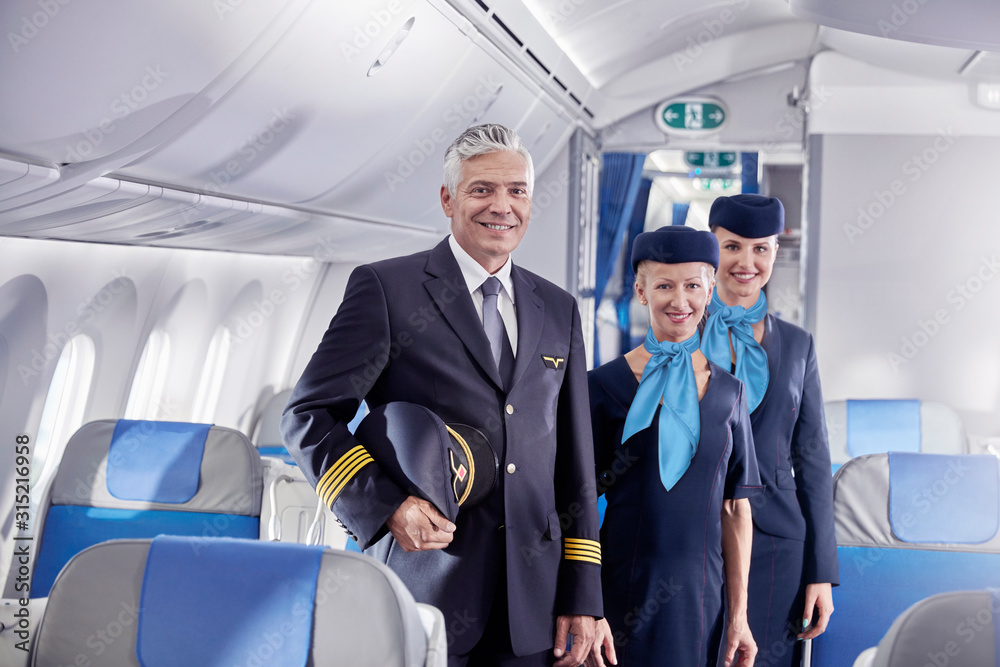 Portrait confident pilot and flight attendants on airplane Stock Photo ...
