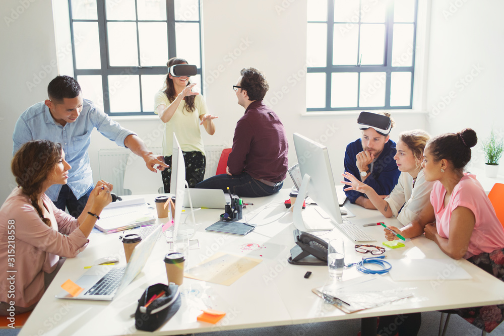 Computer programmers programming virtual reality simulator glasses in open plan office Stock ...