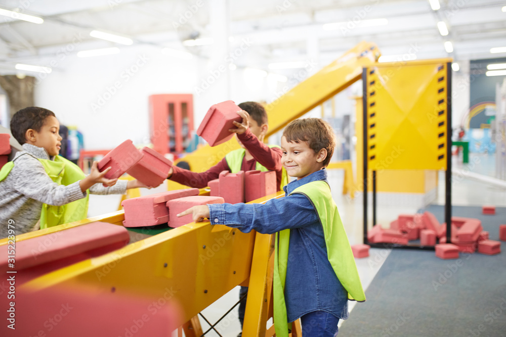 Kids playing toy bricks at interactive construction exhibit in science ...
