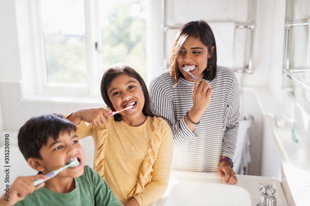 Portrait happy family brushing teeth in bathroom Stock Photo | Adobe Stock