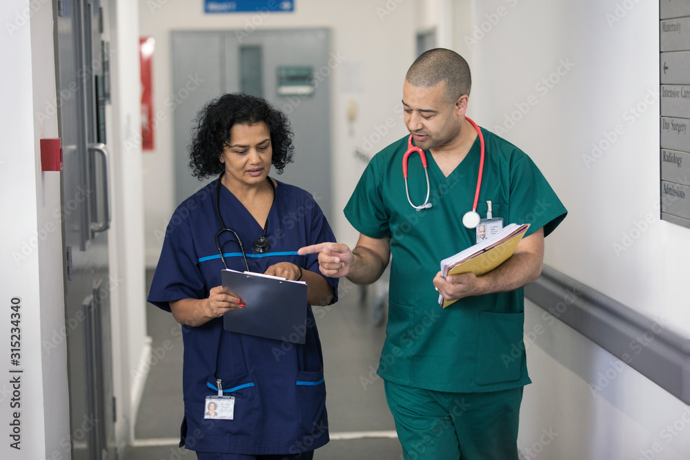 Doctor and surgeon discussing medical chart, making rounds in hospital ...
