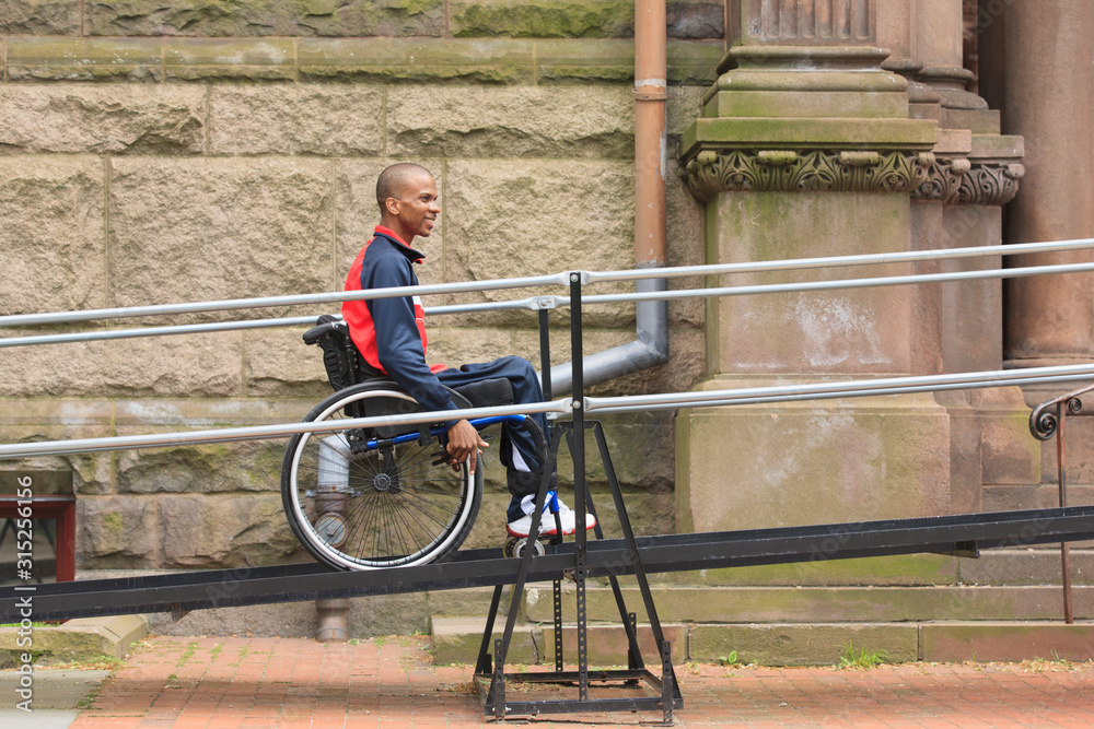 Man in wheelchair using a ramp Stock Photo | Adobe Stock