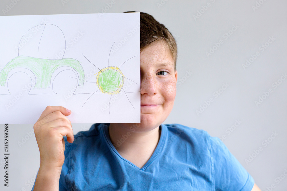 Boy holding drawing of car and sun Stock Photo | Adobe Stock