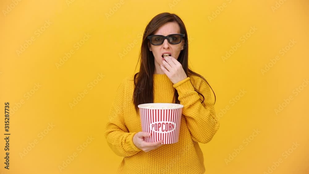 Fun young woman in 3d imax glasses watching movie film, holding bucket ...