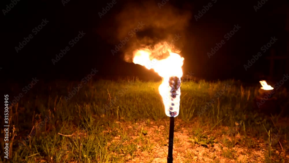 Three torches burn in the dark. Close-up. Slow motion, rotation. Low ...
