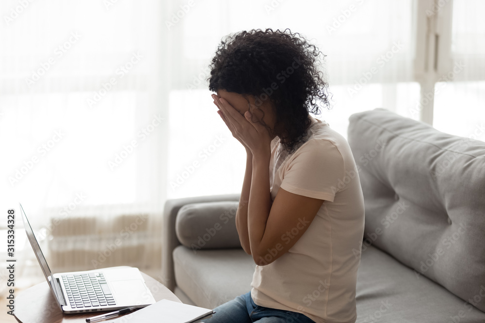 African woman sitting near computer cover face with hands crying Stock ...