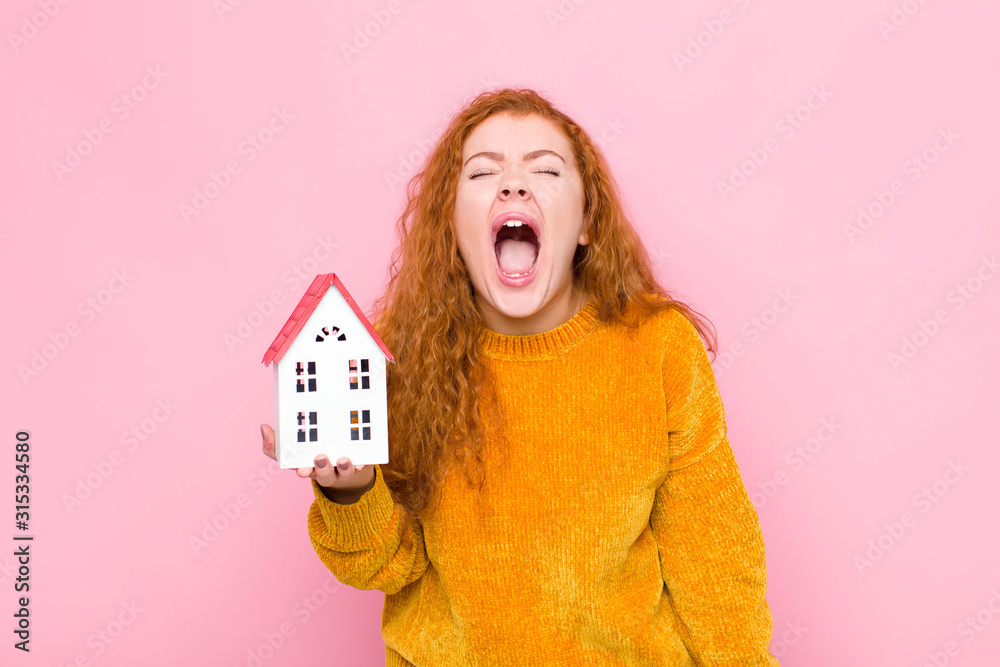 young red head woman shouting aggressively, looking very angry ...
