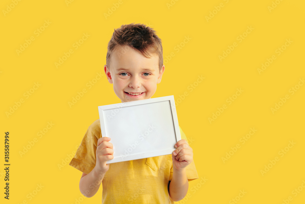 Happy child boy holding a poster for your information on the blue ...