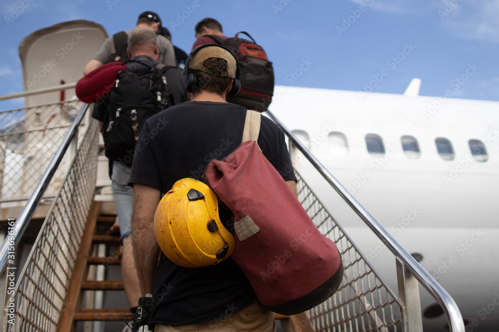 Construction worker carry crimson backpack with yellow fall safety ...