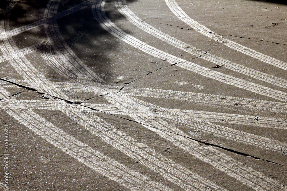 Tire tracks left by cars as they pass by roads filled with volcanic ash ...