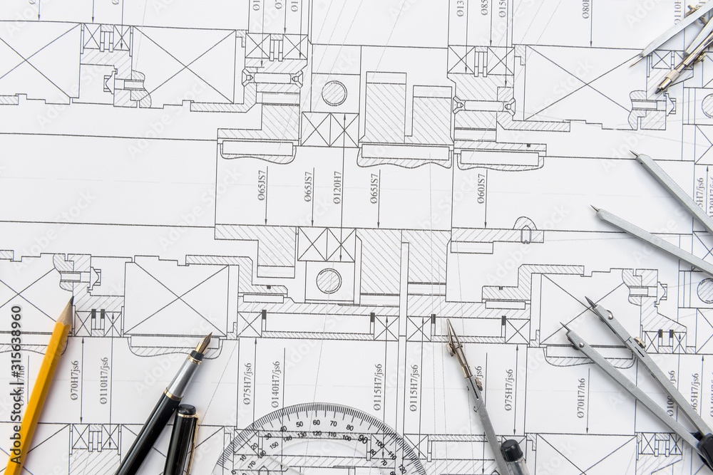 Paper with technical drawings and work tool on table. place of work ...