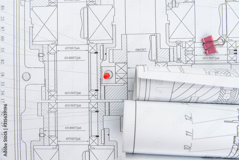 Paper with technical drawings and work tool on table. place of work ...