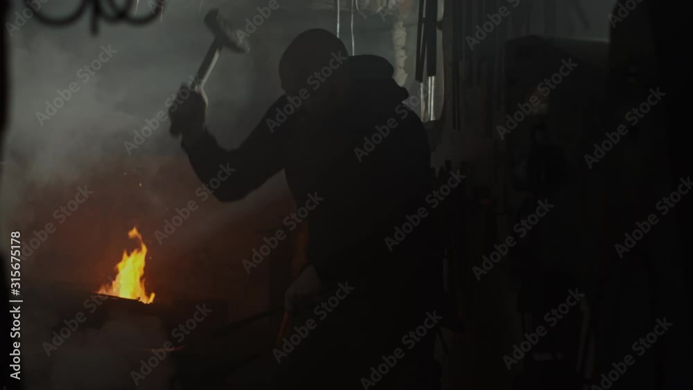 blacksmith hammering a piece of iron. hand held slow motion in 4k Stock ...