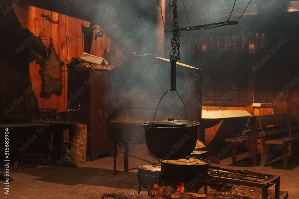 Large cooking pots are prepared using firewood.Metal boilers over a ...