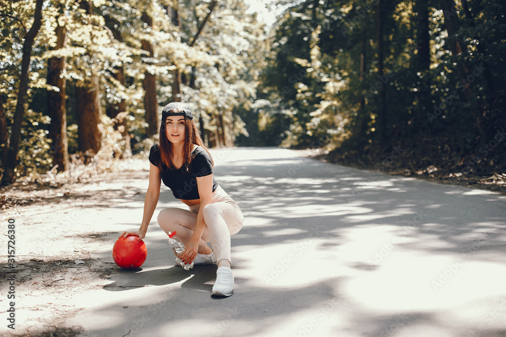 Beautiful sportsgirl in a summer forest. Lady in a black top. Woman ...