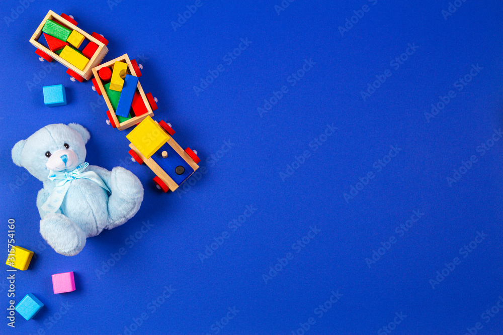 Baby kids toys background. Wooden train, blue teddy bear and colorful ...