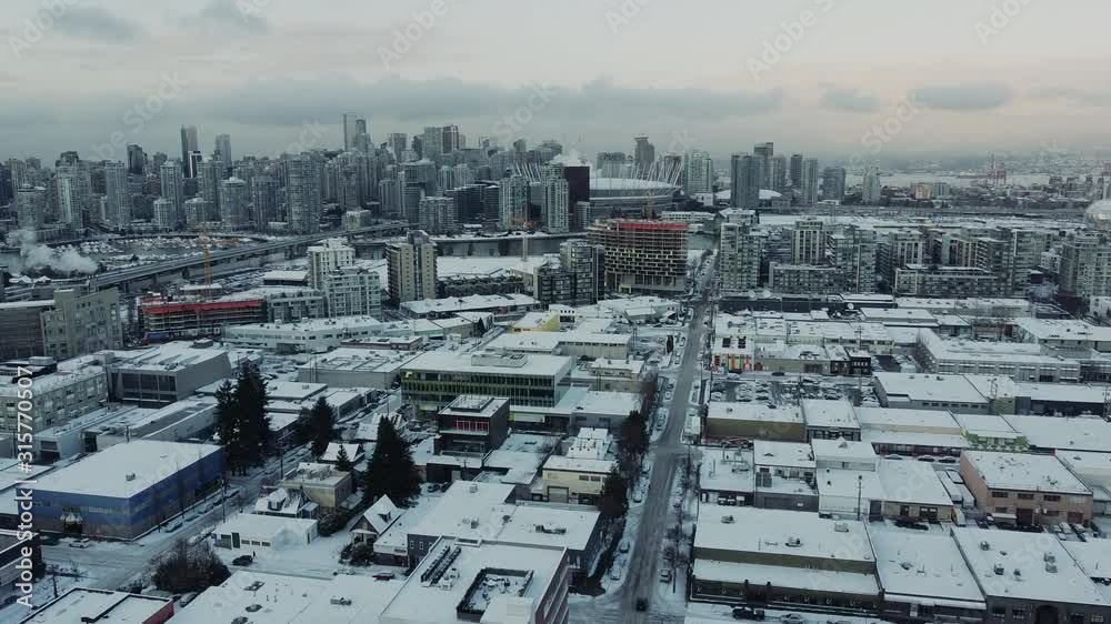 Fly over snow roofs and opening of Vancouver downtown in the winter ...