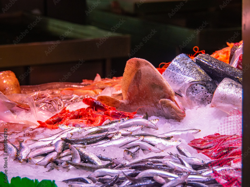 Different kinds of frozen fish and seafood in market ice box, medium ...