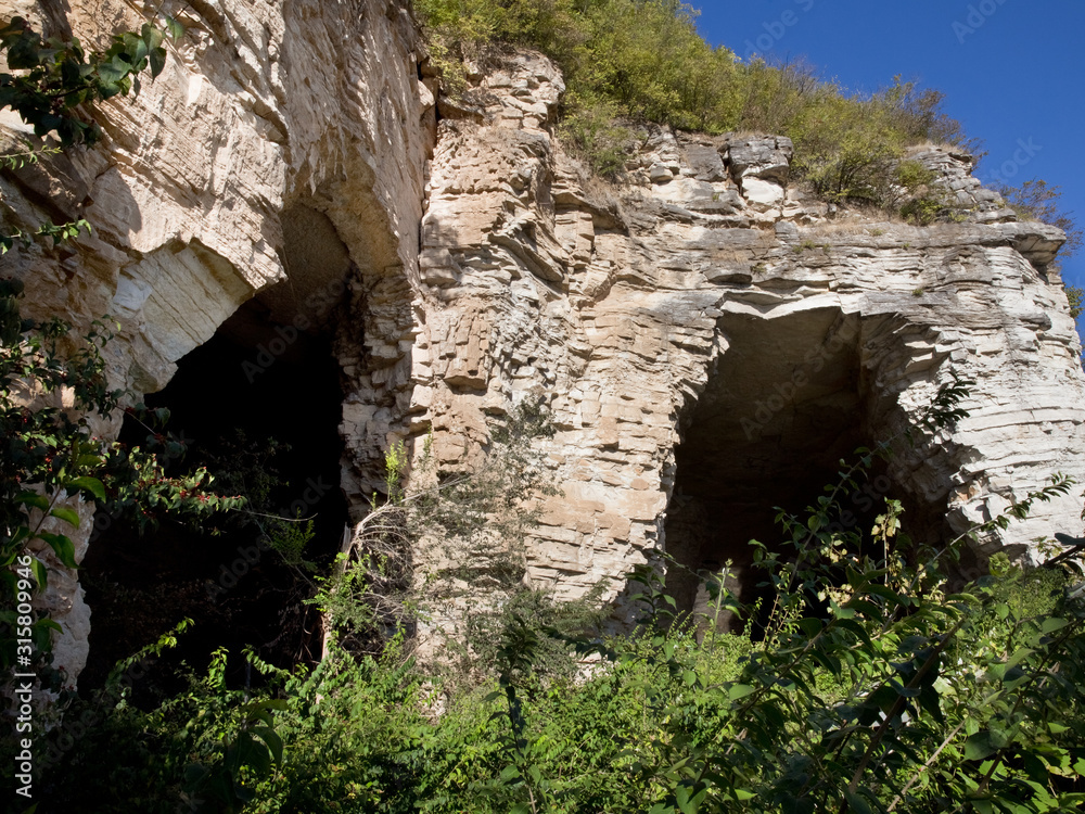 Two large cave openings on limestone bluff along the Mississippi River ...