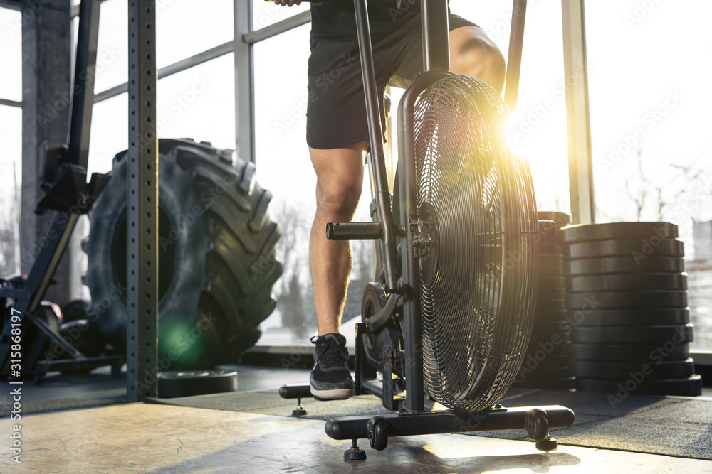 Strong, self control. Young muscular caucasian athlete training in gym ...