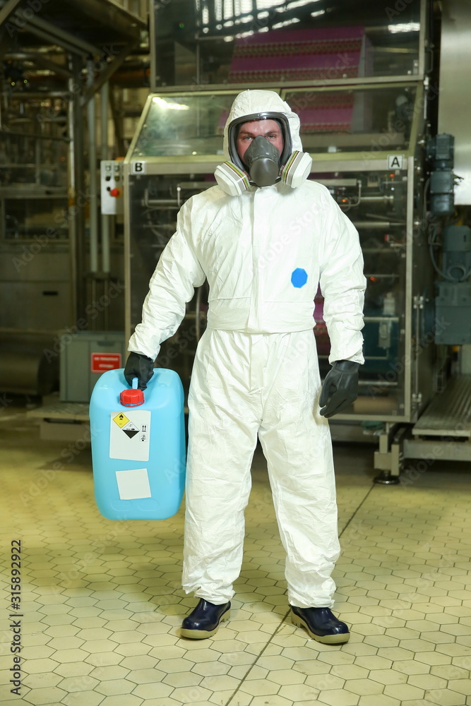 worker male in personal protective equipment and gas mask holding a ...