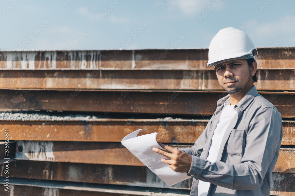 Engineer construction holding blueprint in his hand. Construction site ...