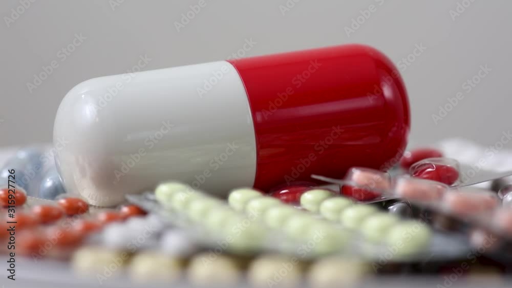 Closeup rotating pile of colorful pills with big pill on top Stock ...