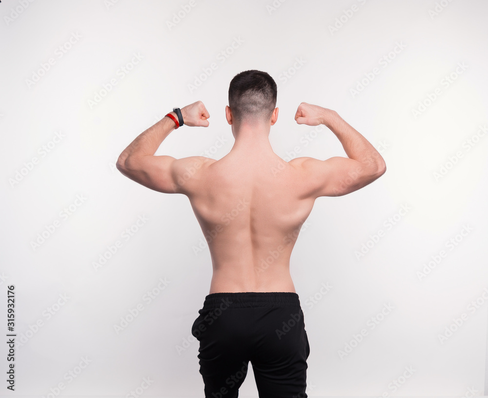 Athletic fitness model posing back muscles, triceps, over white ...