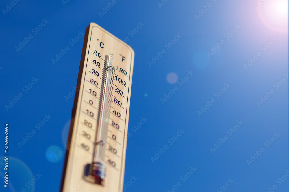 Thermometer on the blue sky background. Weather forecast and ...