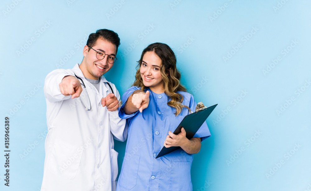 Young doctor couple posing in a blue background isolated cheerful ...