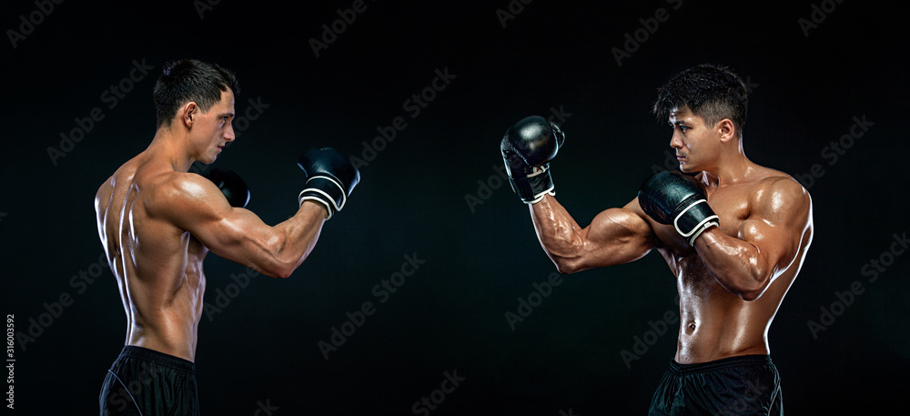 Boxers. Two male fighters in boxing gloves in combat racks on a black ...