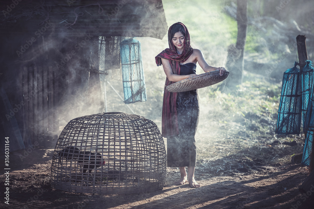 Beautiful girl winnowing rice separate between rice and rice husk ...