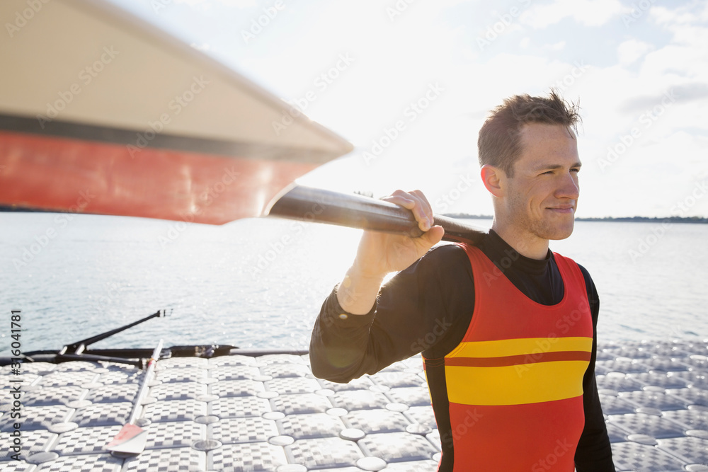 Rower with oar at waterfront Stock Photo | Adobe Stock