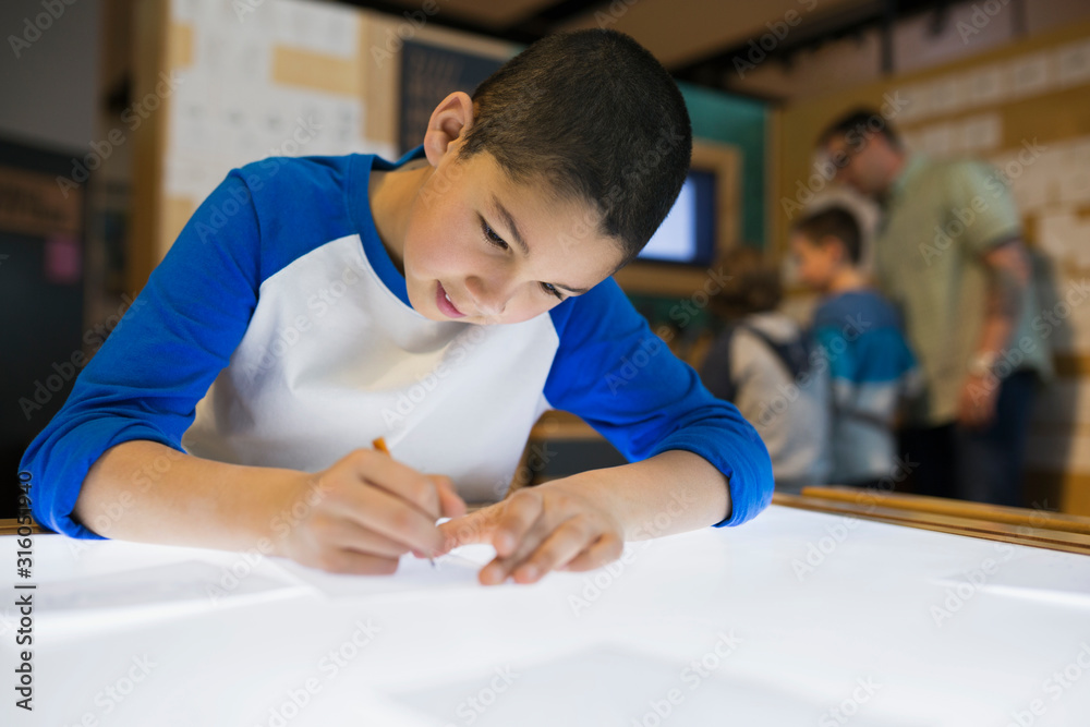Boy tracing at light table at science center Stock Photo | Adobe Stock